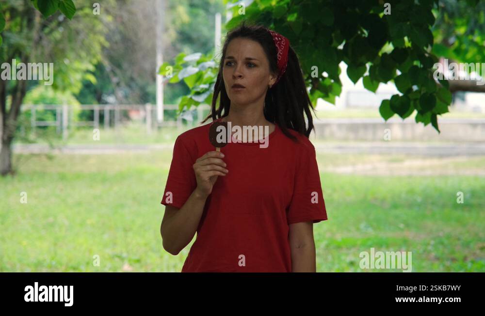 A woman with dreadlocks enjoys ice cream outside Stock Video Footage ...