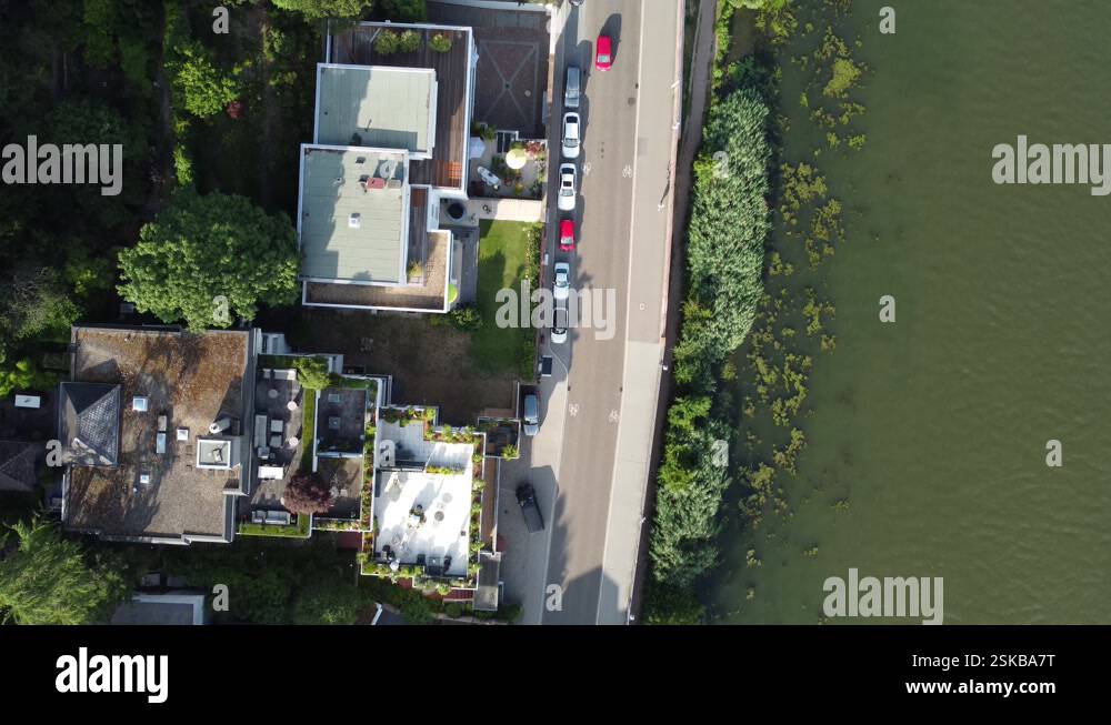 Cinematic overhead parrarrel to the river bank and the buildings over ...