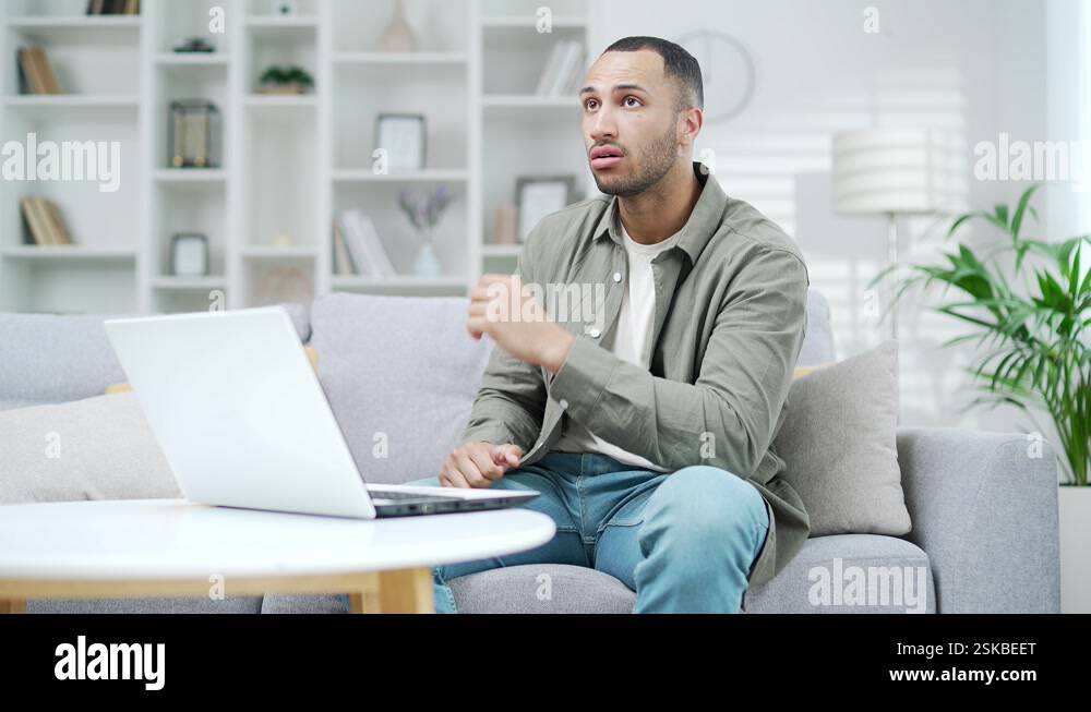 confused young man receiving message with bad news reading notification ...