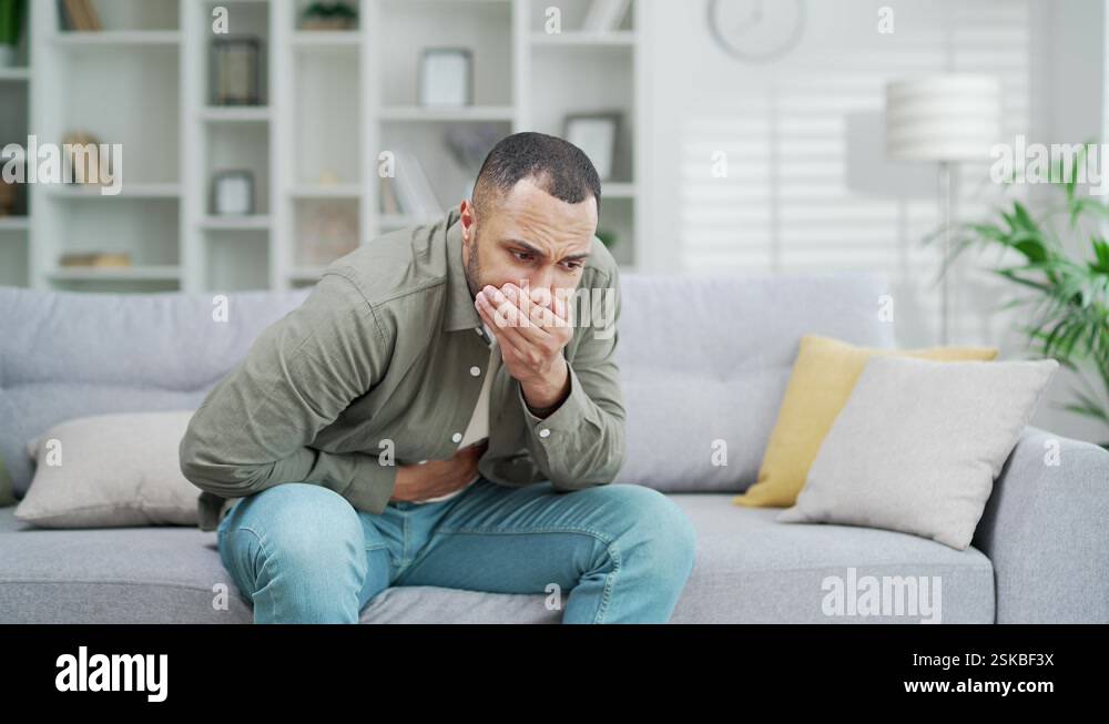 A young adult man is suffering from vomiting and nausea during ...