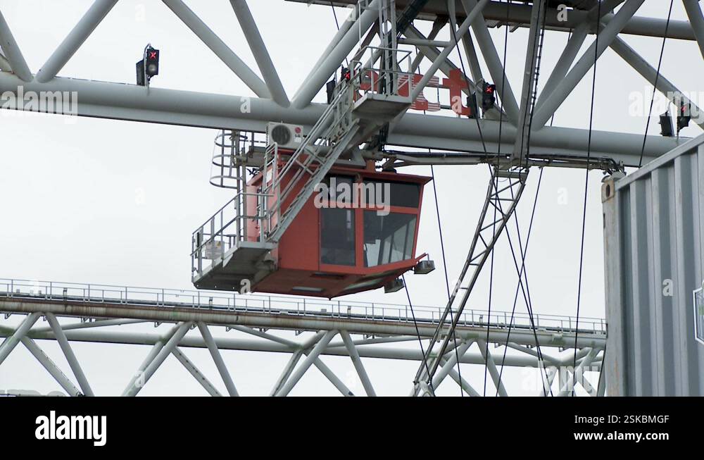 Red crane operator cab at Europort harbour moving around, telephoto ...