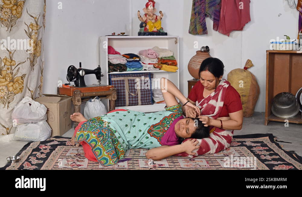 A young teenage girl is scratching her head while lying down on her ...