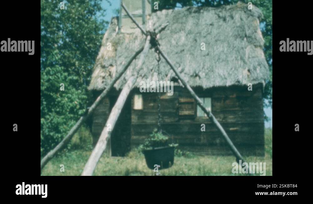 1960s: Small house with a thatch roof and unfinished boards. A tripod ...