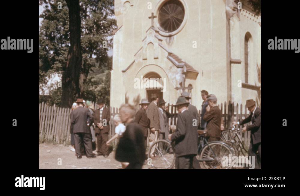 1960s: Church. People stand in groups and speak. Men push bicycles ...