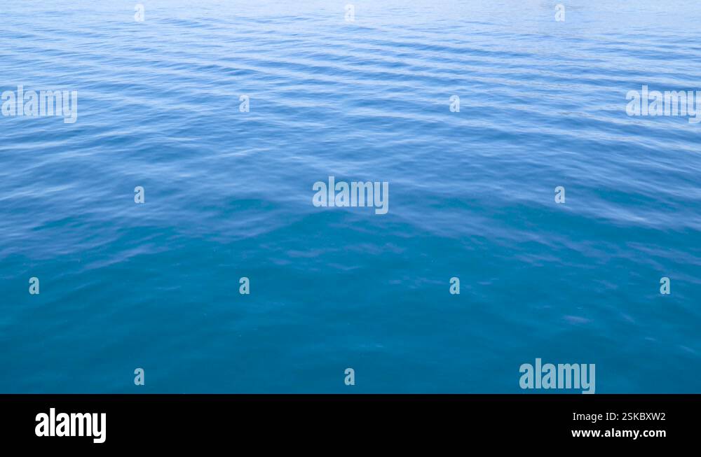 Bright calm blue deep ocean water ripples and flows left to right Stock ...