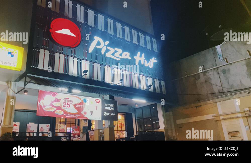 Pizza Hut outlet in Indonesia at night with the lights on Stock Video ...