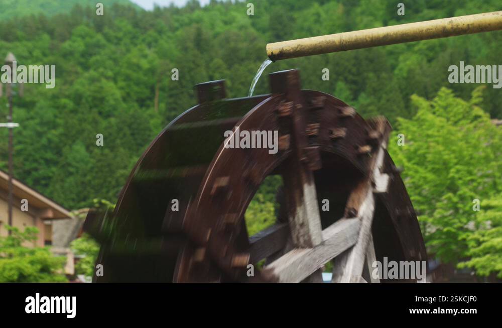 Water Coming Out Of Pipe Onto Spinning Traditional Water Wheel In ...