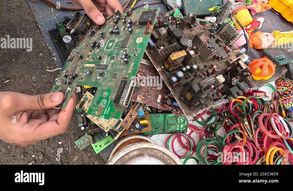 Scene from above showing a man checking a scrap computer motherboard ...