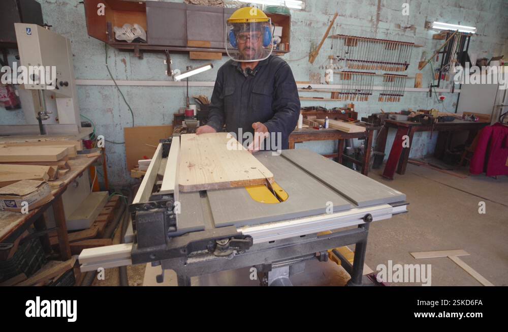 Typical scene from carpenter work environment, operating table saw ...