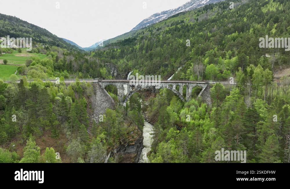 Aerial approaching historic Kylling railway bridge passing above Verma ...