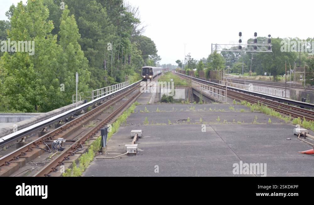 commuter train arrives at station passing through the trees arriving at ...