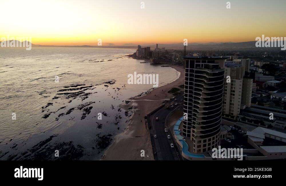 Stunning vivid sunset aerial tilt-up reveals stretch of beach in Strand ...