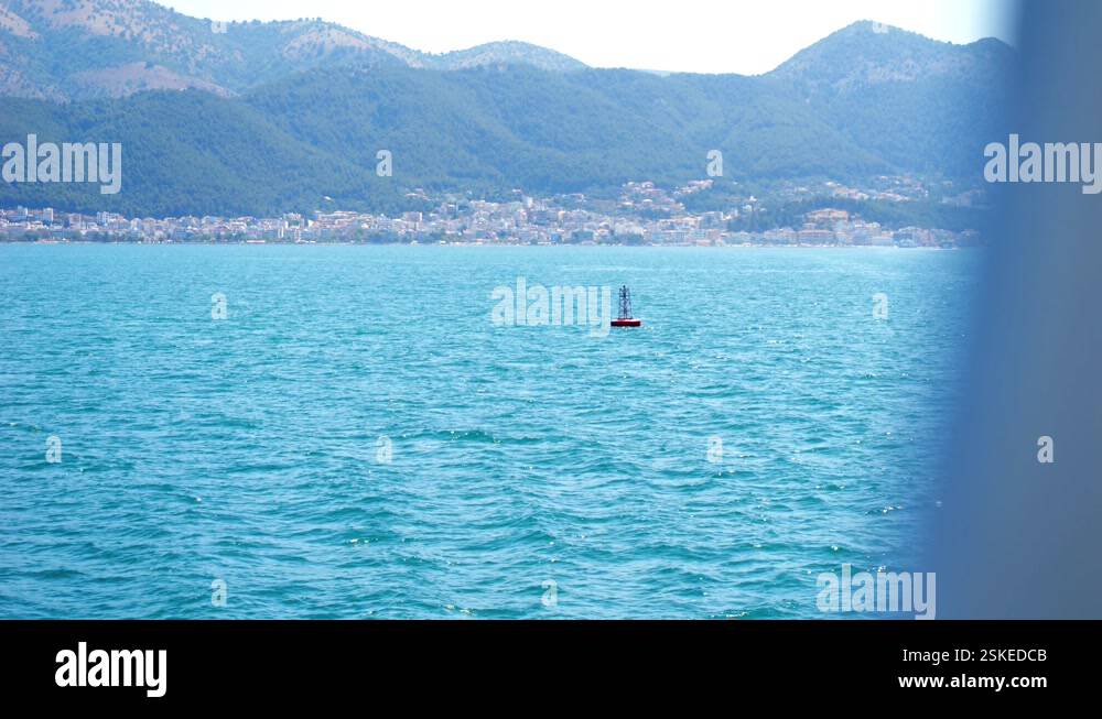 Green buoy floating on the blue waters of the Ionian Sea, with the ...