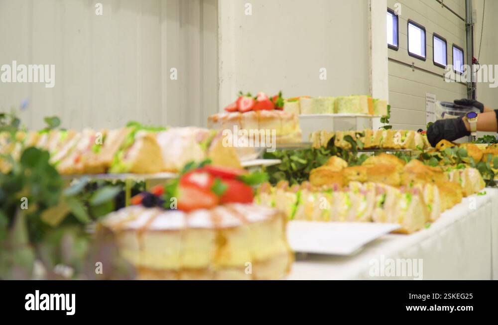 Buffet inside a warehouse filled with cake fruits and lots of ...