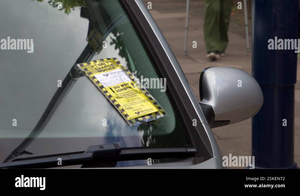 A penalty charge notice yellow sticker on a car windscreen as a parking ...