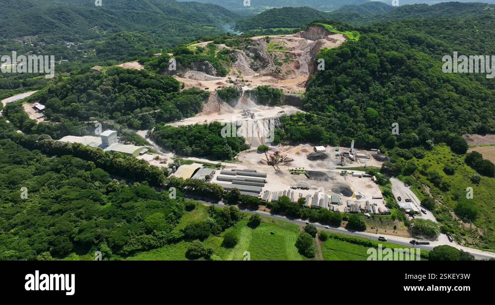 Extracting raw materials for cement from a hill. Trucks and machinery ...