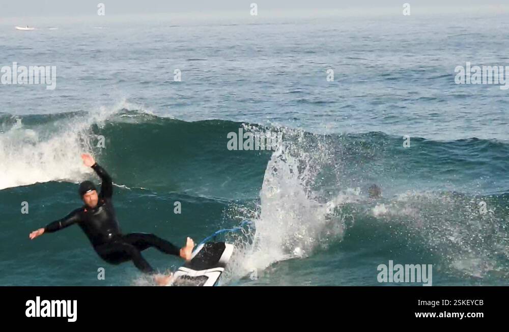 Surfer falls on hydrofoil surfboard riding blue ocean wave. Futuristic ...