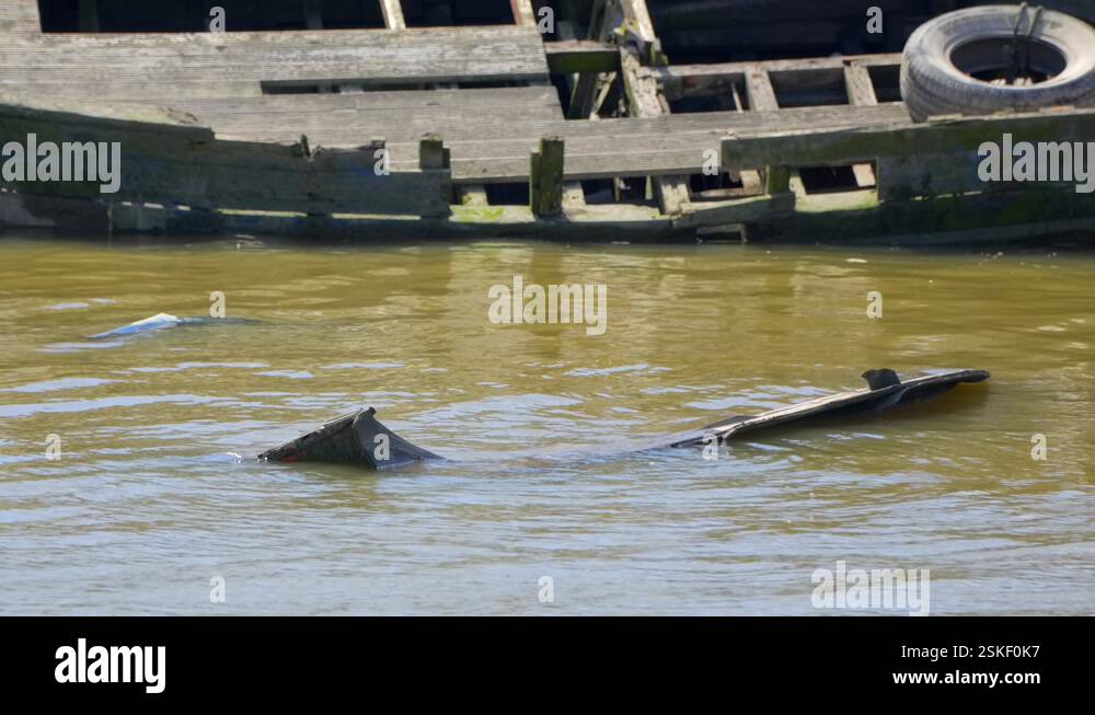 Shipwreck and dirty river water rippling in sunlight. Slow motion x4 ...