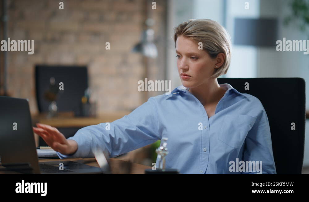 Serious lady opening laptop sitting empty workplace close up. Woman ...