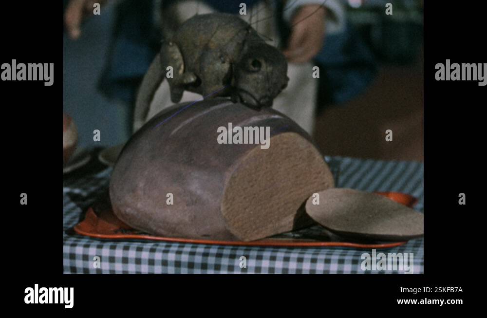 1960s: Puppet show. Rat on loaf of bread. Woman chases rat away Stock ...