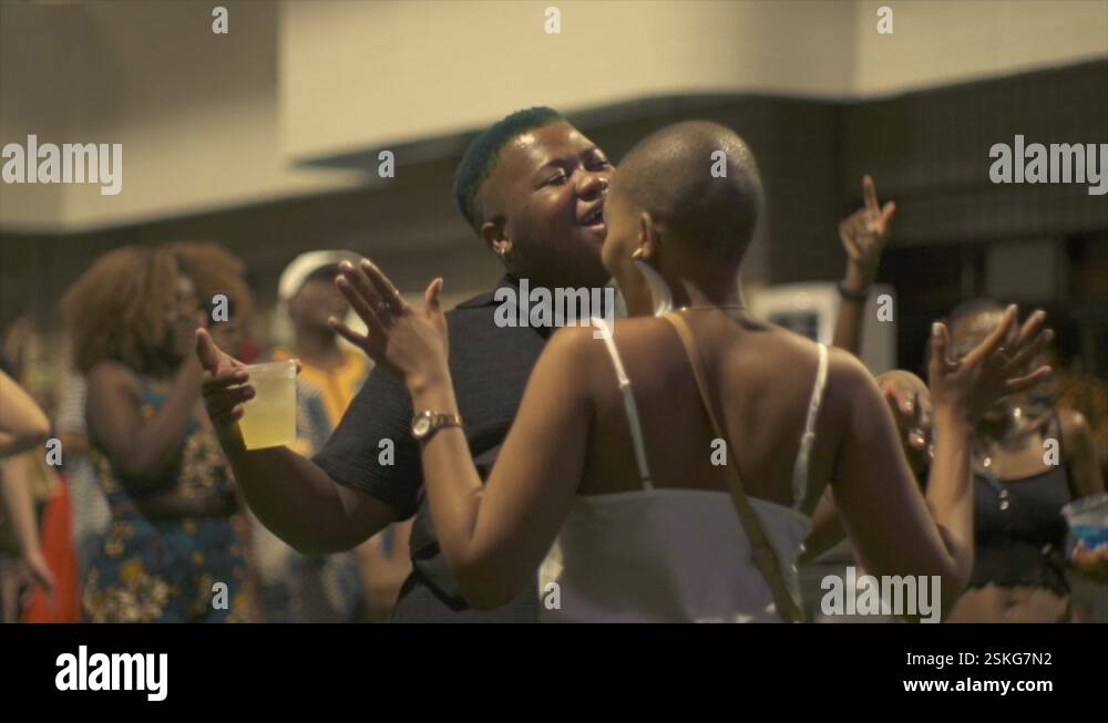 African male and female with short and bald head dancing to live music ...