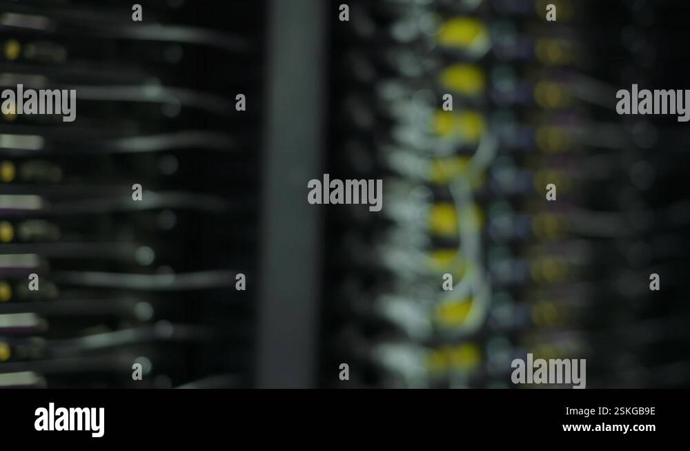Slow pan of server rack cables in data centre and panel switch ports ...