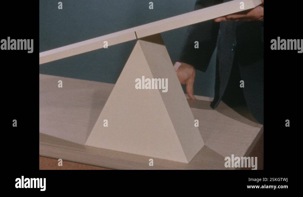 1960s: Hands holding board over pyramid, hands replace pyramid under ...