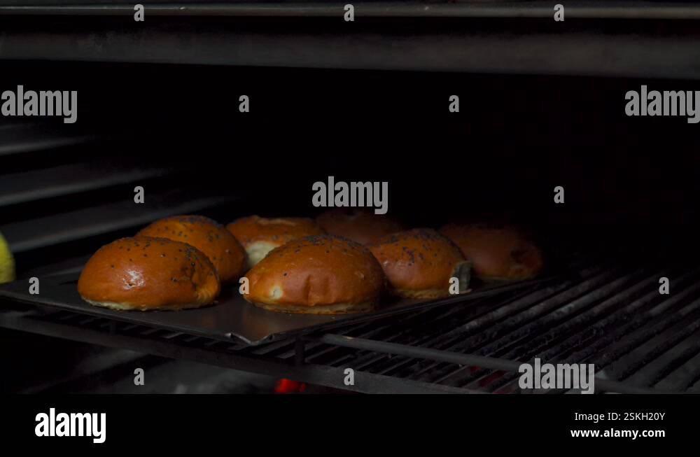 Baker chef cooker take out fresh hamburger buns of charcoal fire grill ...