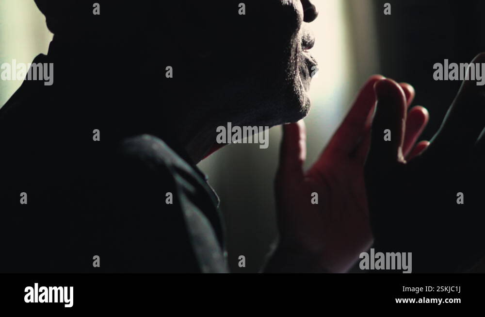 Candid scene of a senior African American man Praying to God in bedroom ...