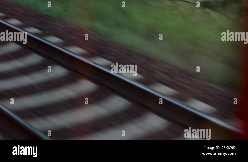 Look out of the window of a rolling train, fast moving rail tracks in ...