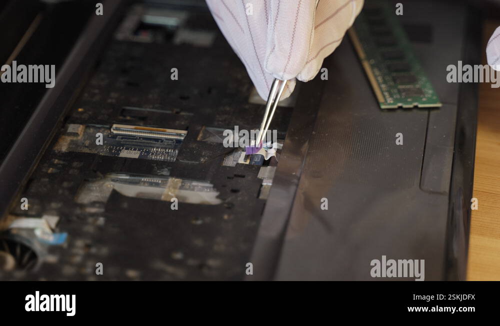 Man with hand in glove opens connector with tweezers and disconnects ...