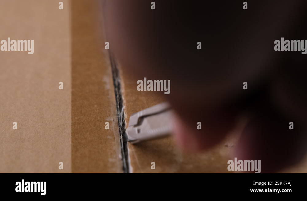 Close-up of woman's hand opening box using cutter. Hands unpacking ...