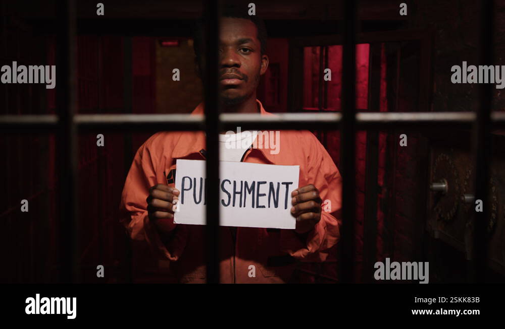 Sad convicted black man holding cardboard sign with word Punishment in ...