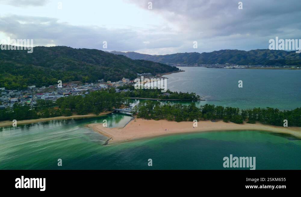 Orbiting aerial view of Amanohashidate pine-covered sandbar one of ...