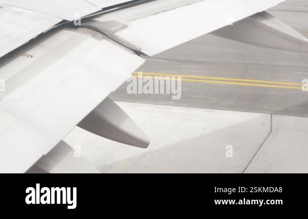view to rear wing of a airplane with wing flap while flaps deploying ...