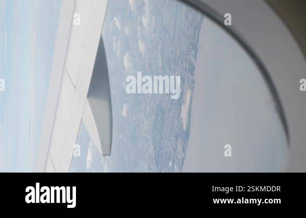 vertical view of plane's wing over blue sky with white fluffy clouds ...