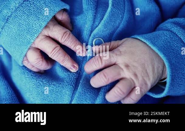 Newborn baby wearing blue outfit, showing tiny fingers and hands in a ...