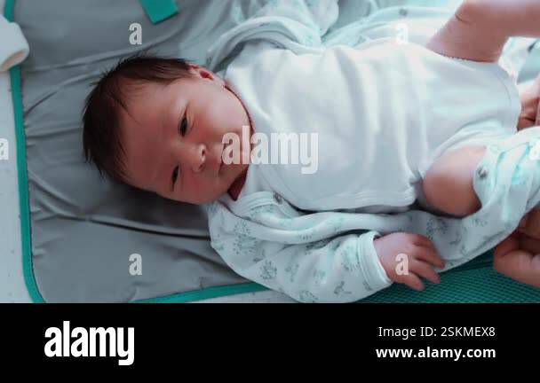 Newborn baby engaged in observing surroundings as mother carefully ...