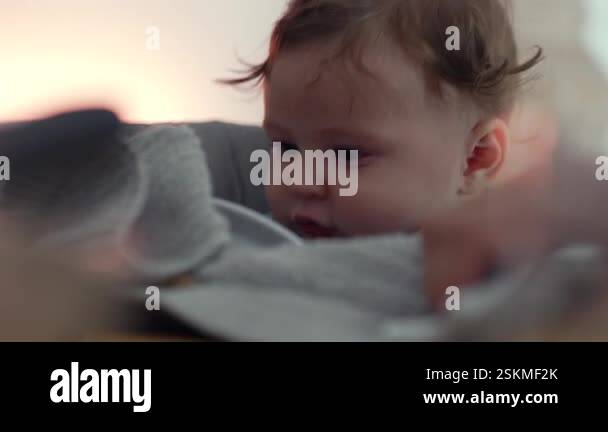 Baby peering at a white plate, intense focus, tactile exploration ...