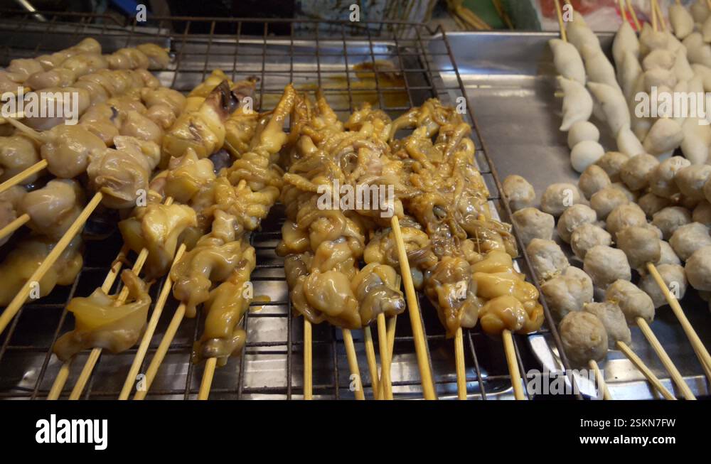 thailand night market street food booth pork organ in bamboo sticks ...