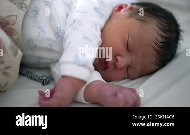 Newborn baby peacefully sleeping on a bed, showcasing the tranquility ...