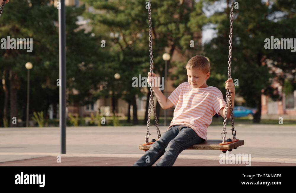 Boys swing on swings, friends play in childrens park. Children swinging on swing Stock Video ...