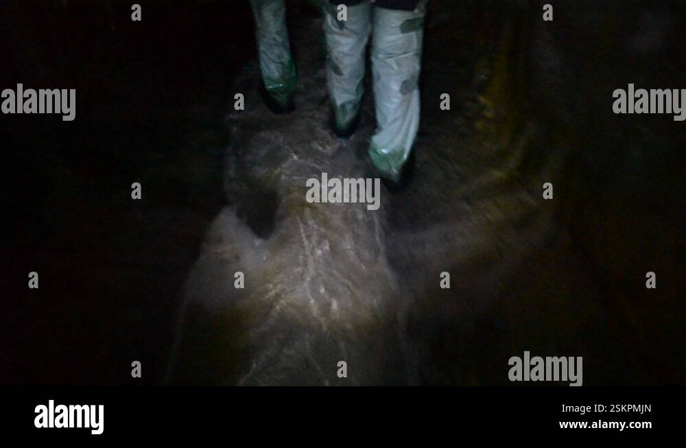 People diggers rubber boots walking underground river tunnel adit rain ...