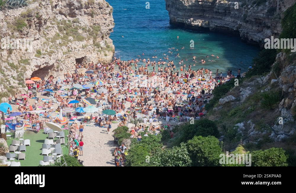 The crowded beach in Polignano a mare in Puglia Italy, zoom out Stock ...