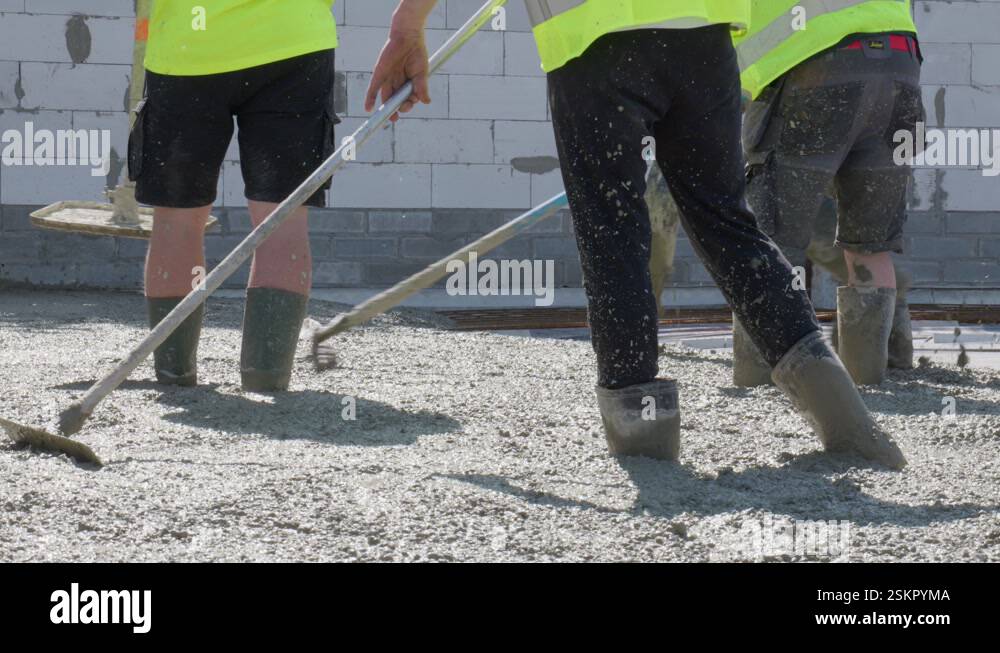 Construction Workers In Boots Using Concrete Kumalong To Pull And Push ...