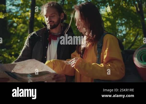 Young tourists hiking in the woods, navigating their route via road map ...