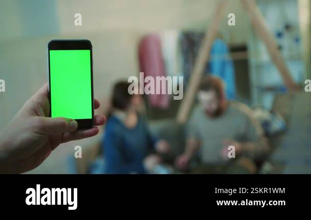 Close up hand man holding phone with vertical green screen in ...