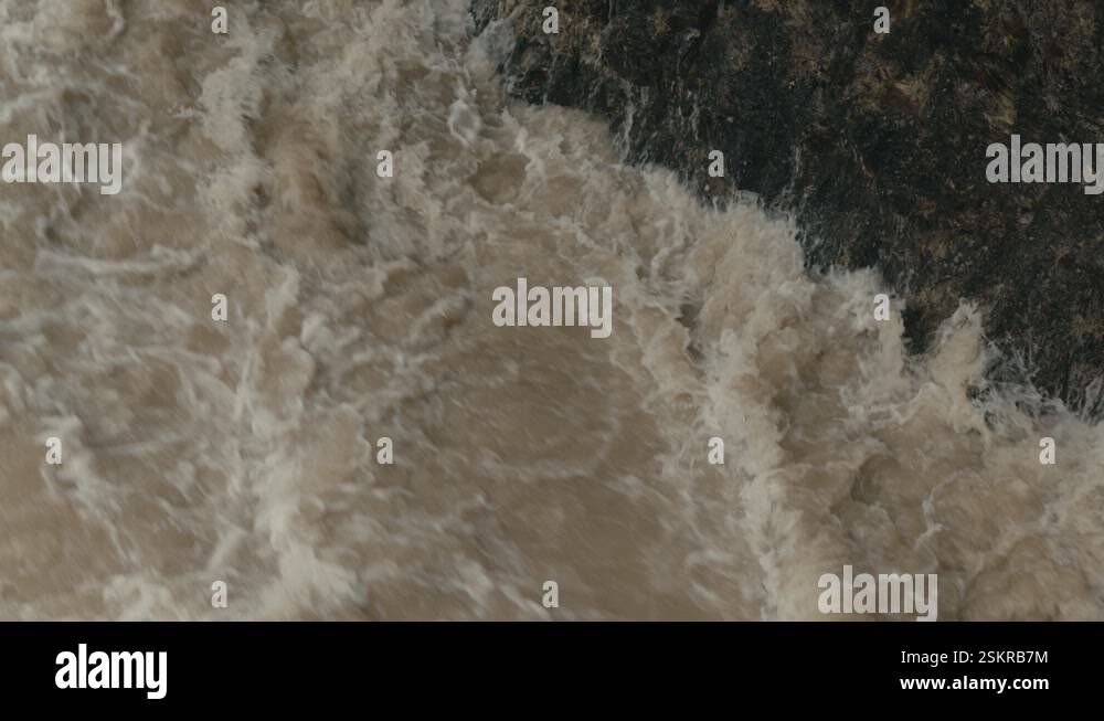 River floods shore overflow high water waves top down in slow motion ...