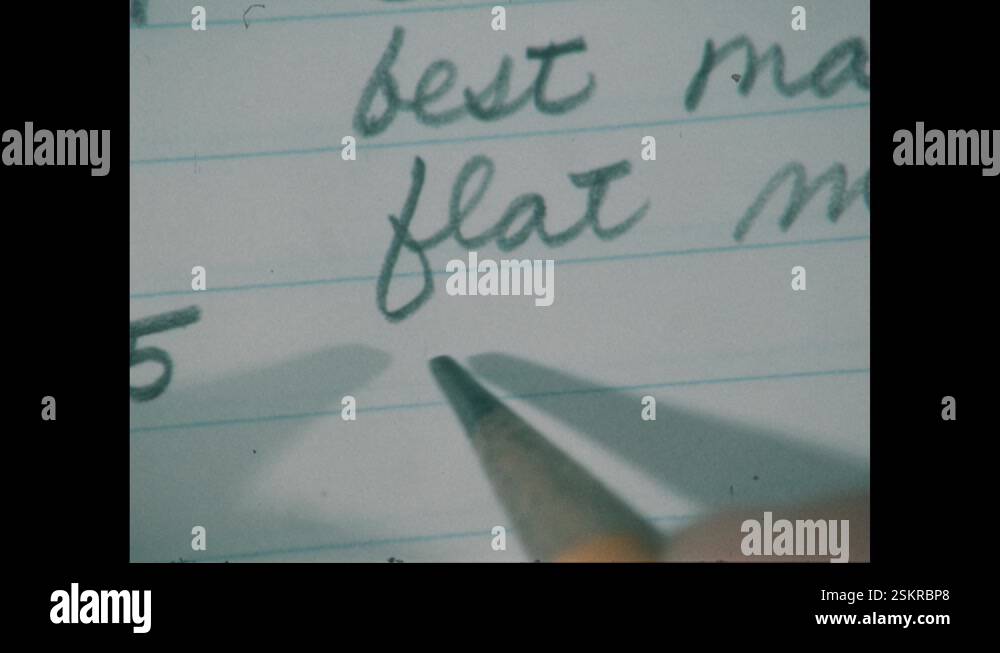 1960s: Hand with pencil writes sentence in cursive on spiral notebook ...