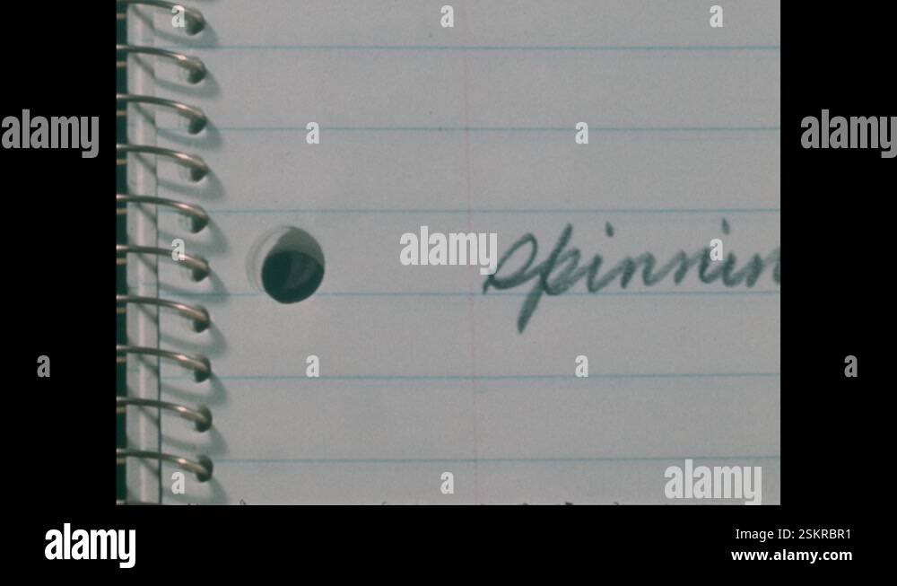 1960s: Hand with pencil writes sentence in cursive on spiral notebook ...